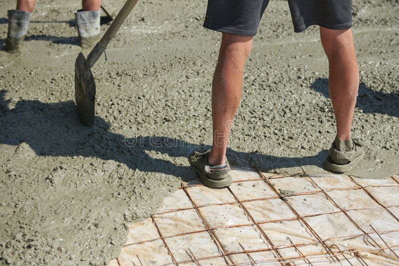 Soiled Construction Worker Stands with His Feet in Concrete on a ...