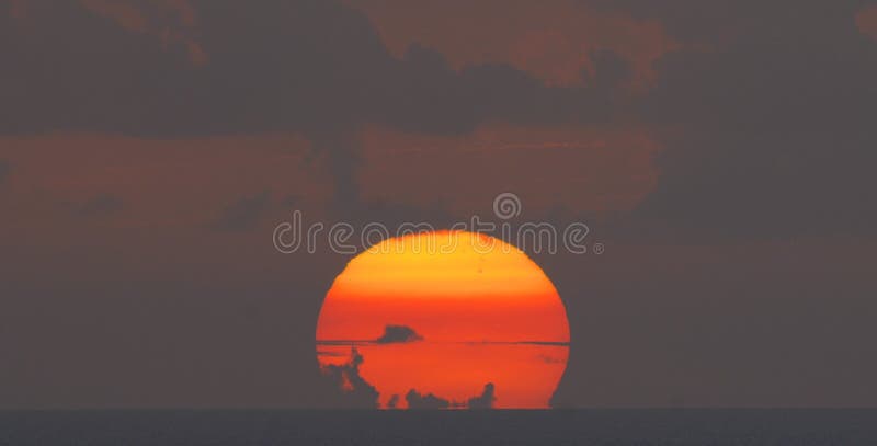 Sol poniente con las nubes foto de archivo. Imagen de costa - 51369980