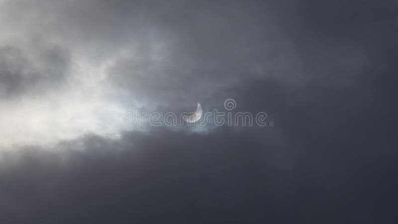 A Solar Eclipse in Cloudy Weather through a Cloud. Partial Solar ...