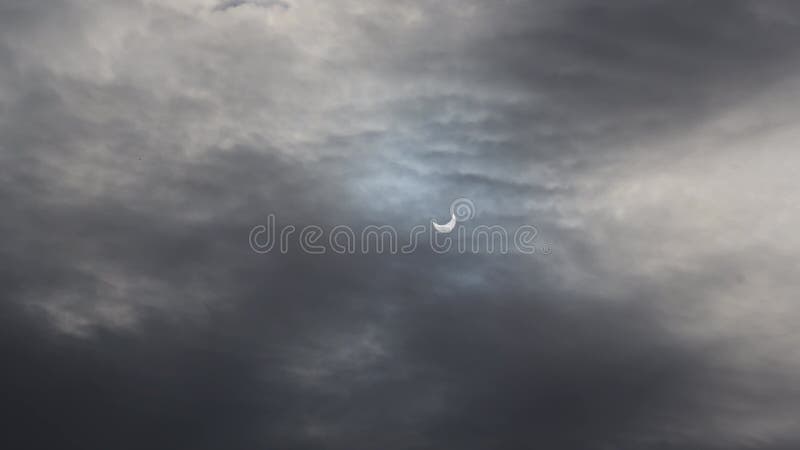A Solar Eclipse in Cloudy Weather through a Cloud. Partial Solar ...