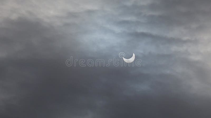 A Solar Eclipse in Cloudy Weather through a Cloud. Partial Solar ...