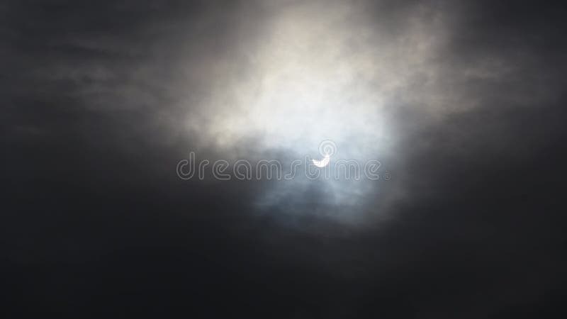 A Solar Eclipse in Cloudy Weather through a Cloud. Partial Solar ...