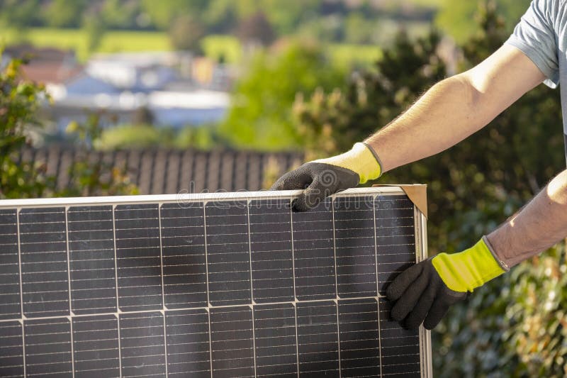 Solar Energy. Solar Panel in the Hands of a Worker on Houses Background ...