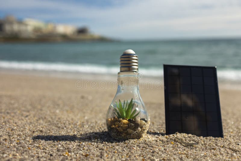 Solar Panel and Light Bulb on the Sand Against the Background of the ...