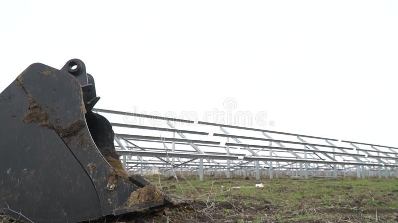 Solar Panel Racks in the Background of a Massive Excavator Bucket ...
