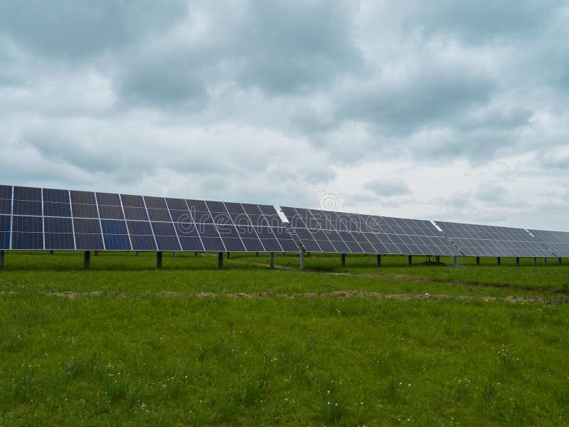 Solar Panels in a Field Under a Cloudy Sky. Clean Energy Solution Stock ...
