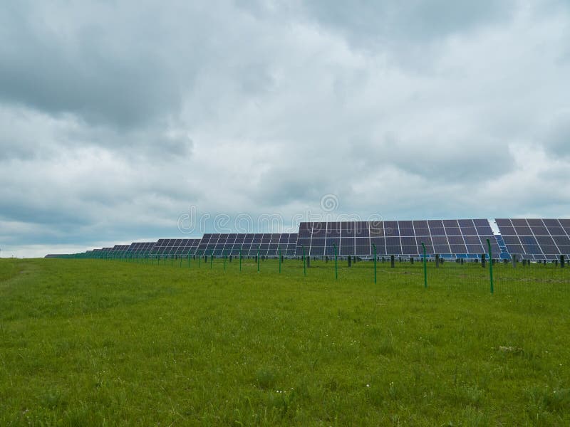Solar Panels in a Field Under a Cloudy Sky. Clean Energy Source in a ...