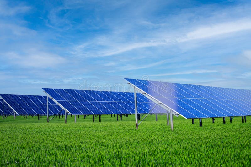 Solar Panels in Green Grass Against Blue Sky: Green Technology Concept ...