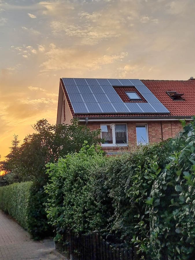 Solar Panels on a Red Tiled Roof of a Building, Evening Sky Stock Photo ...