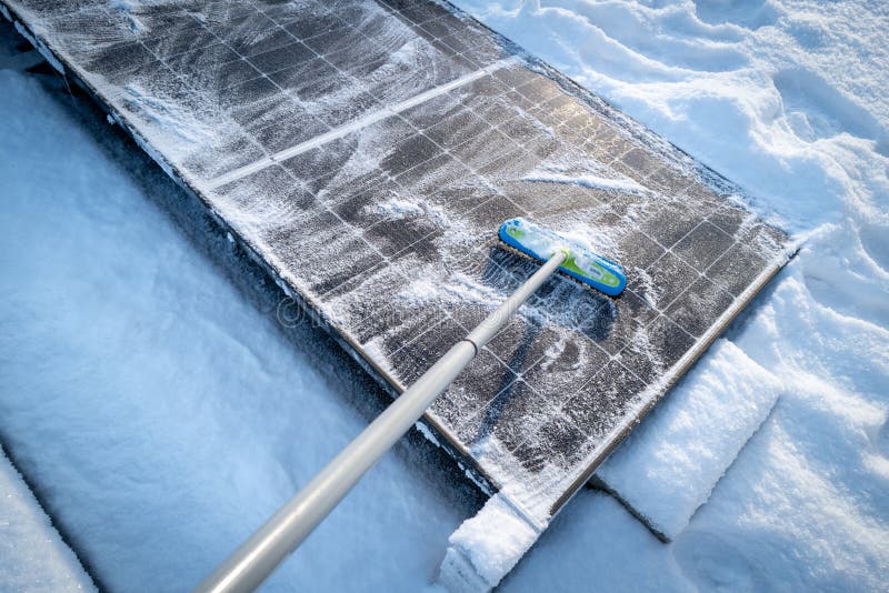 Solar Panels on the Roof are Cleaned from Snow with the Broom Stock ...