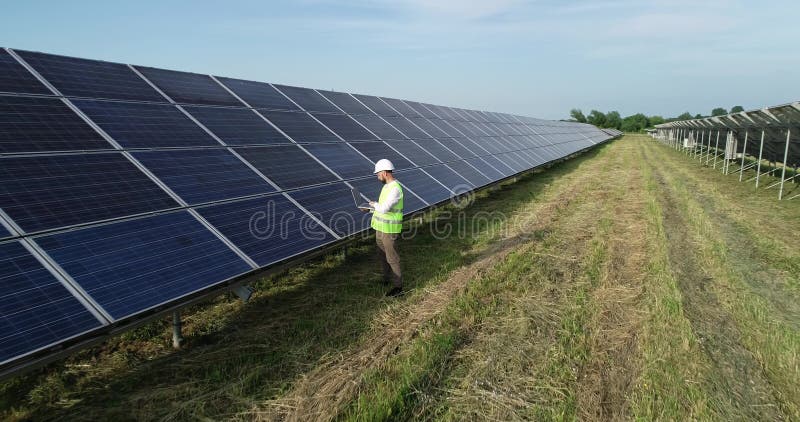 Solar Power Engineer Working on a Solar Farm. Drone Shot Stock Image ...
