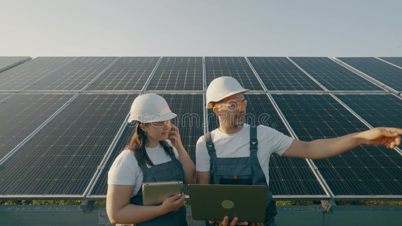 Solar Power Plant Workers with a Laptop Discuss the Operation of the ...
