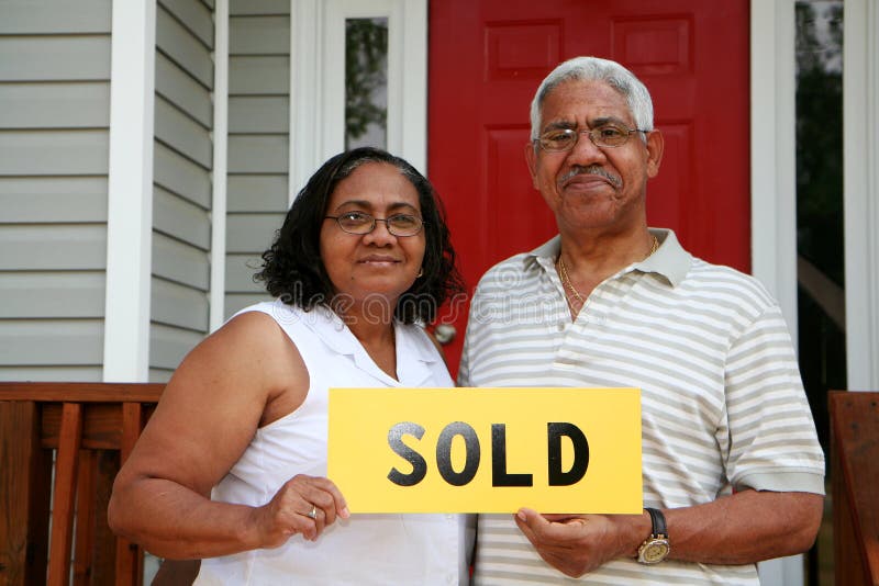 Senior Couple in Front of Sold Real Estate Sign and House Stock Photo ...
