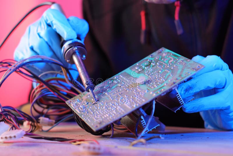 Soldering on the Board a Red Transformer Soldering Iron by a Person ...