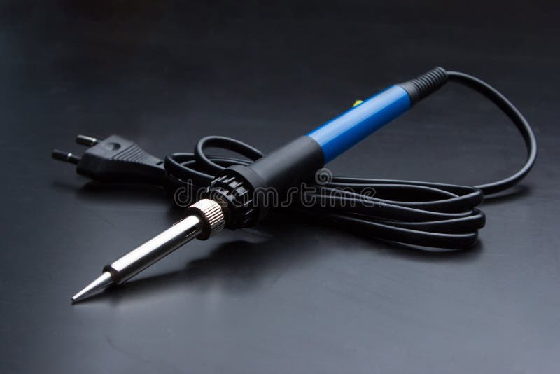 Soldering Iron with a Blue Handle on the Old Black Desktop Surface ...