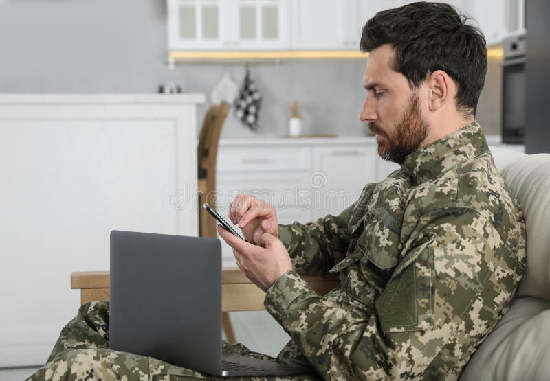 Soldier with Laptop Using Smartphone at Home Stock Photo - Image of ...