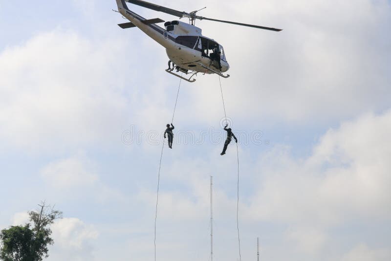 Soldier Rappelling from Helicopter in Blue Sky with Blur Propeller ...