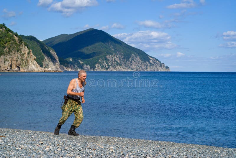 Soldier runs at sea 1 stock photo. Image of pistol, cape - 11412762