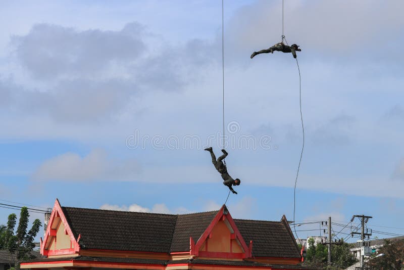 Soldier Rappelling from Helicopter in Blue Sky with Blur Propeller ...