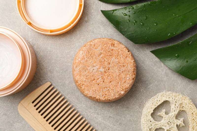 Solid Shampoo Bar, Cream, Monstera Leaf, Comb and Loofah on Grey Table ...