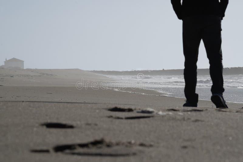 Solitude by the Sea. Low Angle View Silhouette of Boy Walking Along the ...