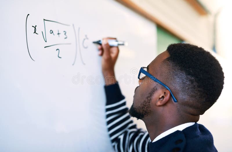 Solving the Equation. a Young Man Writing on a Whiteboard in a ...