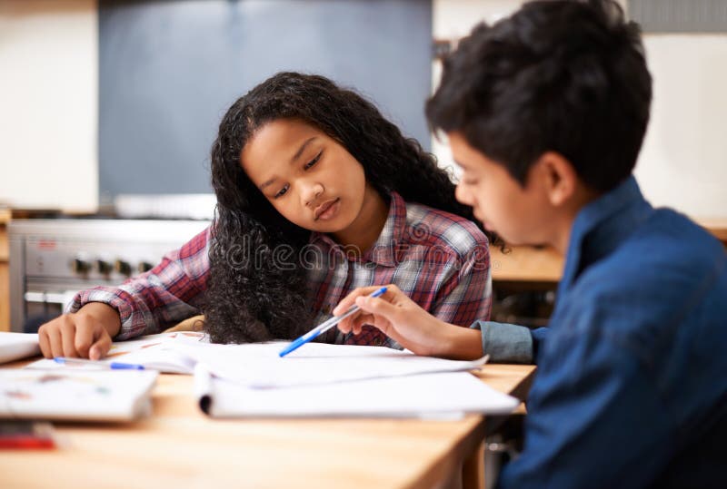 Solving Their Homework Together. Shot of Two Young Students Studying ...