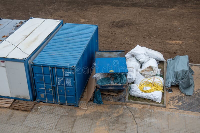 Some Blue and White Construction Containers Stand Next To a Waste ...
