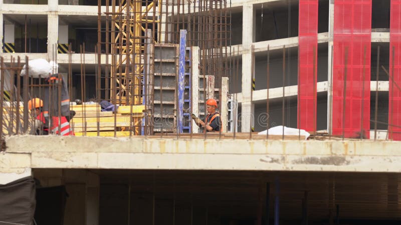 Builders Work Against the Background of an Assembly Crane. Workers at a ...