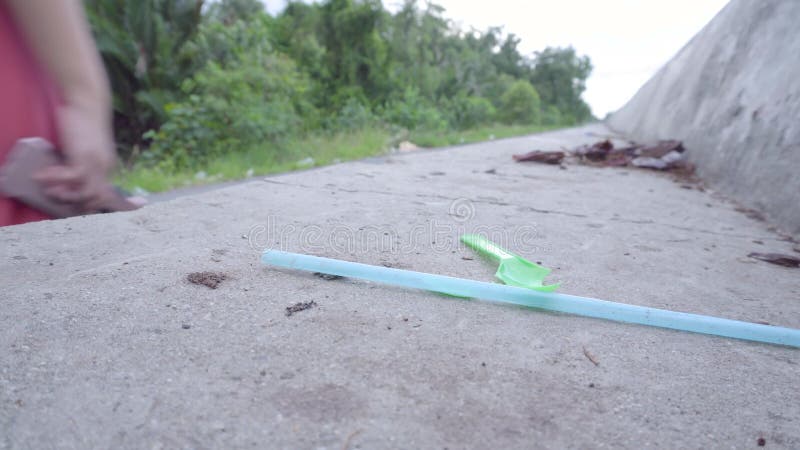 Some Lady Just Passing by a Plastic Straw and Spoon. Pollution from ...