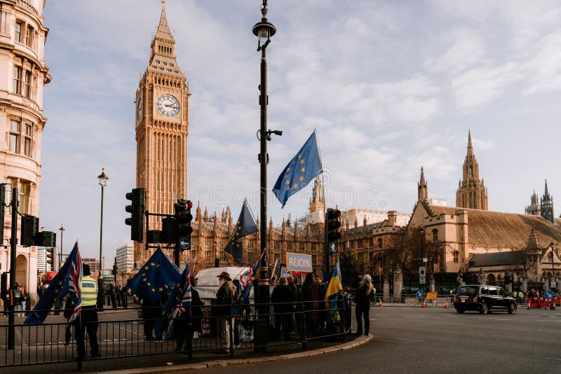 Some People are Standing on the Sidewalk at a Corner in Front of a Tall ...
