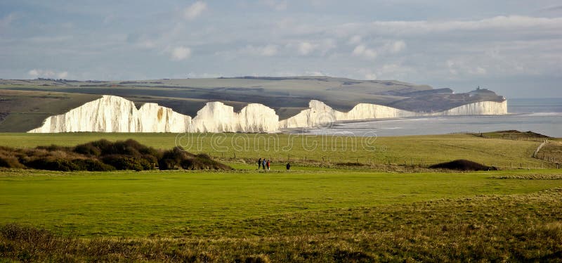 Some People Walk on the Green Grass in Front of the White Cliffs ...