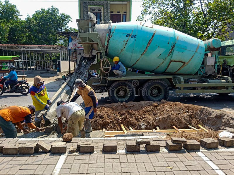 Some People are Working on the Casting of a Water Channel on the Side ...