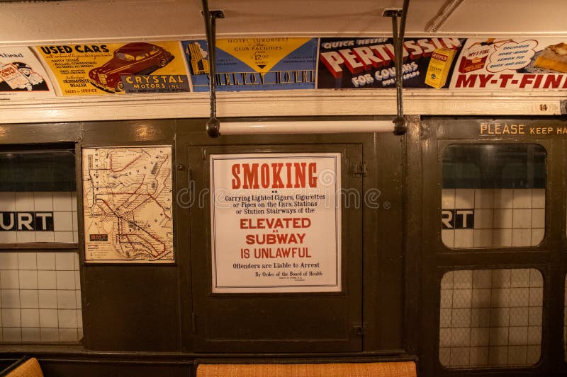 Some Posters and Seating by a Subway Train Wall in the Evening ...