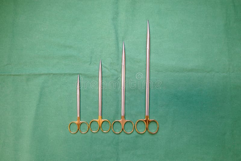 Some Surgical Scissors of Different Sizes Lie Side by Side on a Green ...