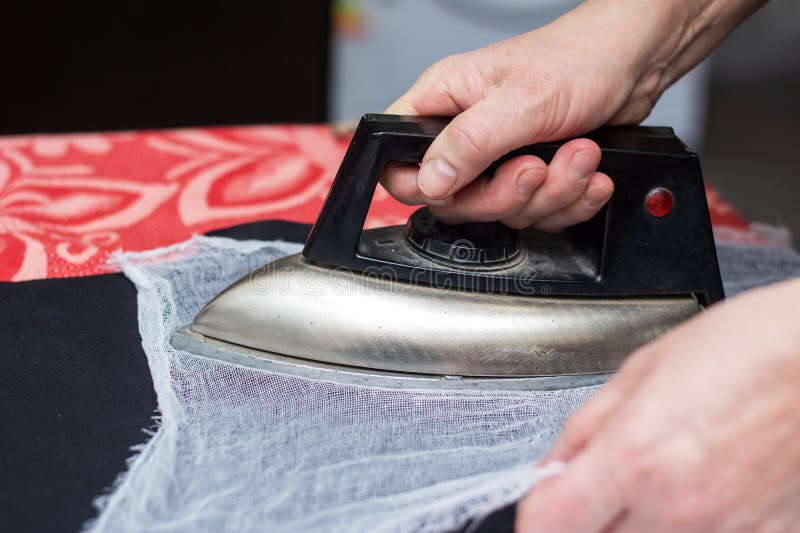 Someone is Using an Iron To Press a Cloth on a Flat Surface Stock Photo ...