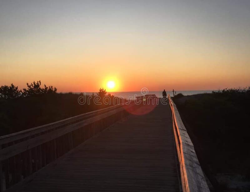 Someone Walking Down the Bridge As the Sun Shines it Sets Stock Photo ...