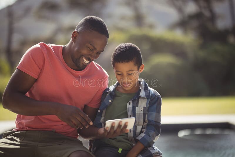 Son and Father Using Mobile Phone Near Poolside Stock Photo - Image of ...