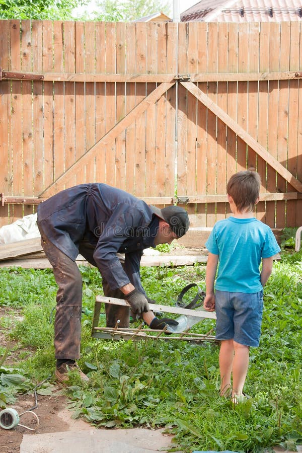 Son watches work of father stock image. Image of looks - 58929165