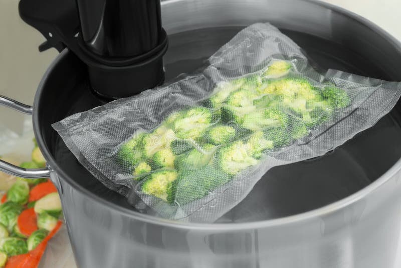 Sous Vide Cooker and Vacuum Packed Broccoli in Pot on Table, Closeup ...