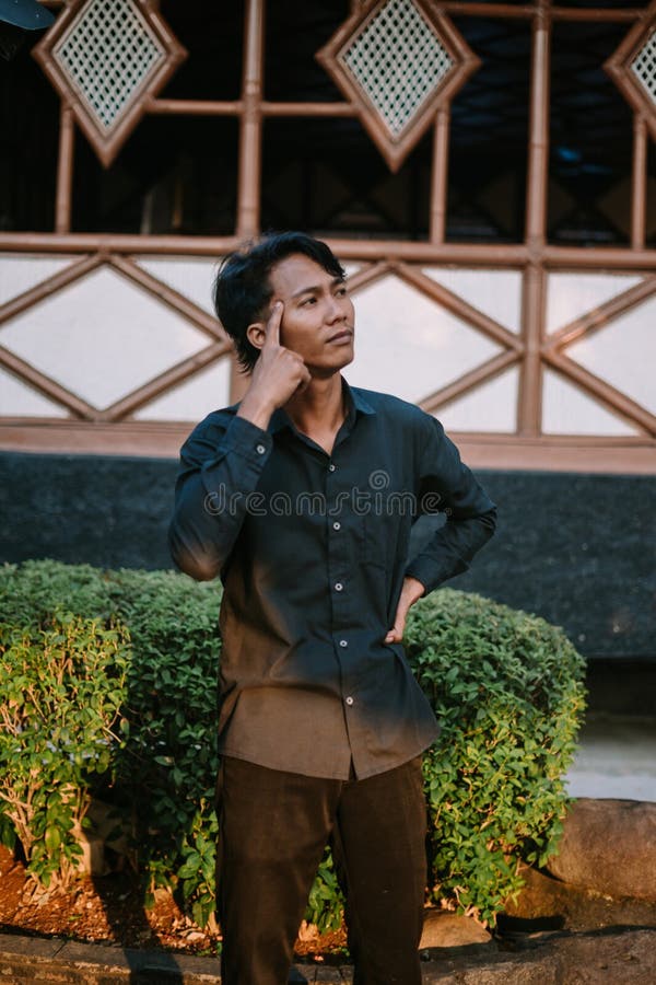 A Southeast Asian Man Deep in Thought, Resting His Hand on His Chin ...