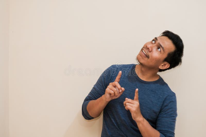Southeast Asian Man Smiling Looking Up and while Two Hands Pointing His ...