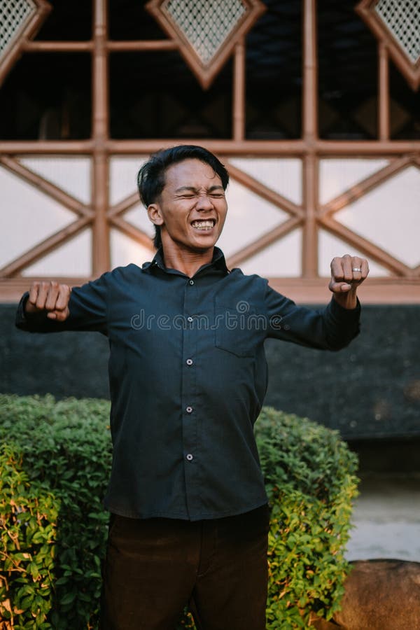 A Southeast Asian Man is Stretching His Back while Pushing His Hips ...