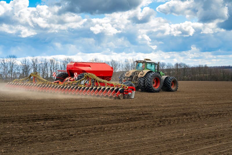 Sowing Work in the Field in Spring. Tractor with Seeder Stock Photo ...