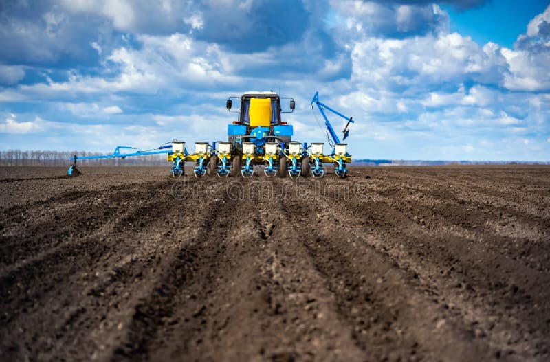 Sowing Work in the Field in Spring. Tractor with Seeder Stock Image ...