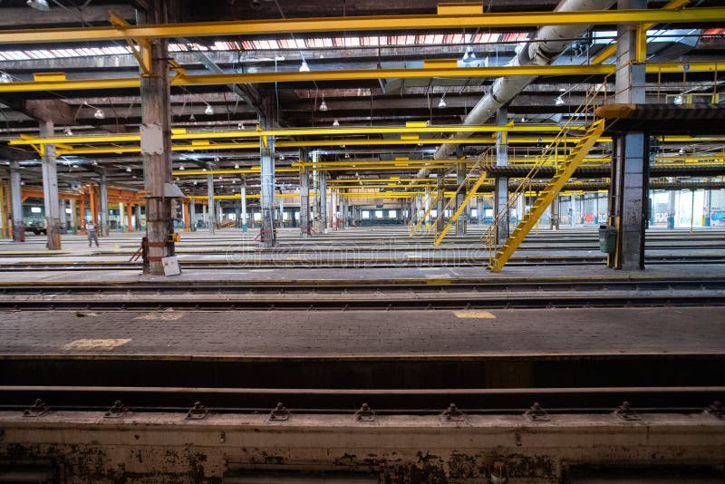 Spacious Abandoned Train Workshop with Yellow Beams and Tracks Stock ...