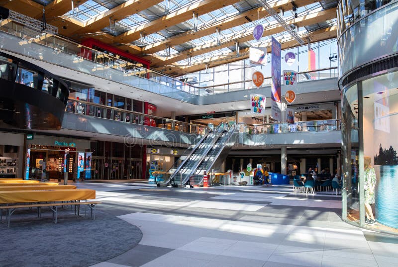 Spacious Shopping Mall Interior with Escalators and Natural Light ...