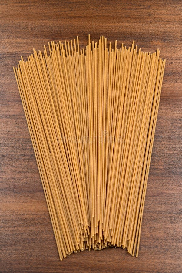 Spaghetti on brown table stock photo. Image of uncooked - 60170002