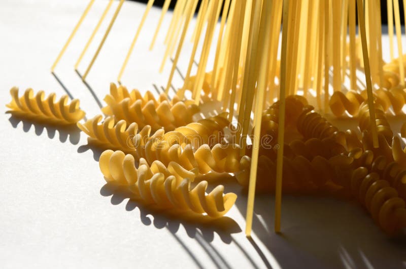 Spaghetti, Fusilli in Sun Light on White Table Stock Image - Image of ...
