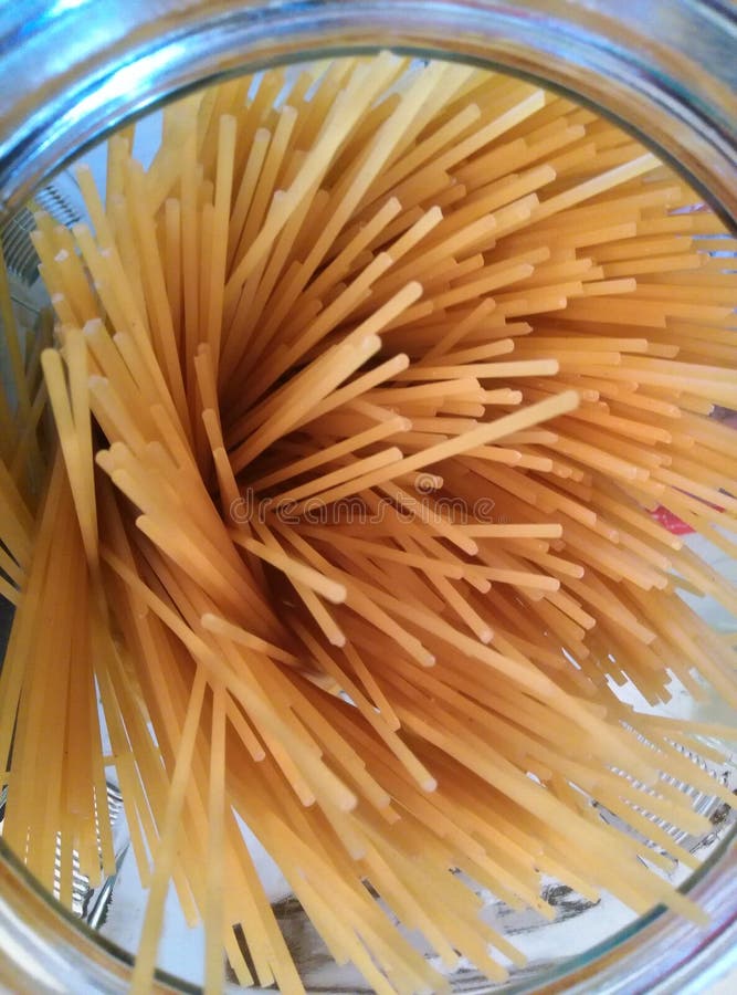 Spaghetti Sticks and Parsley Leaves on Yellow Kitchen Table Background ...